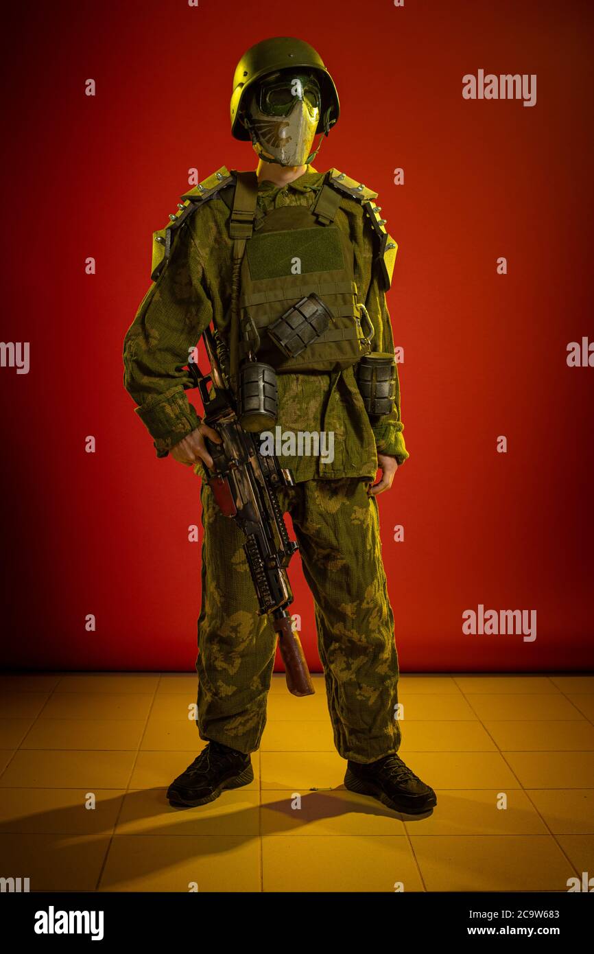 Actor man in a military helmet, mask and uniform posing on a red ...