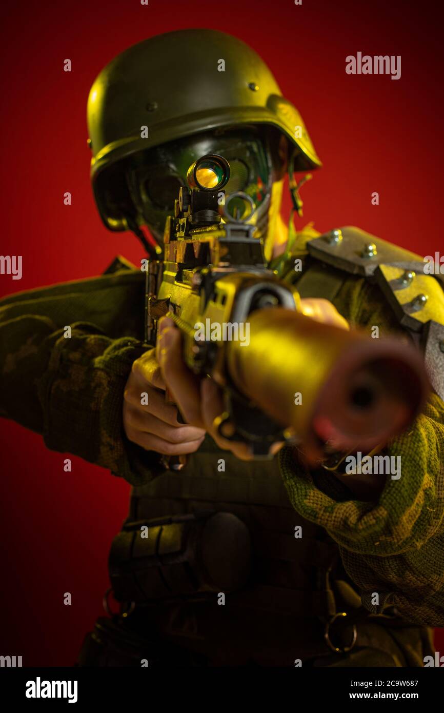 Actor man in a military helmet, mask and uniform posing on a red ...