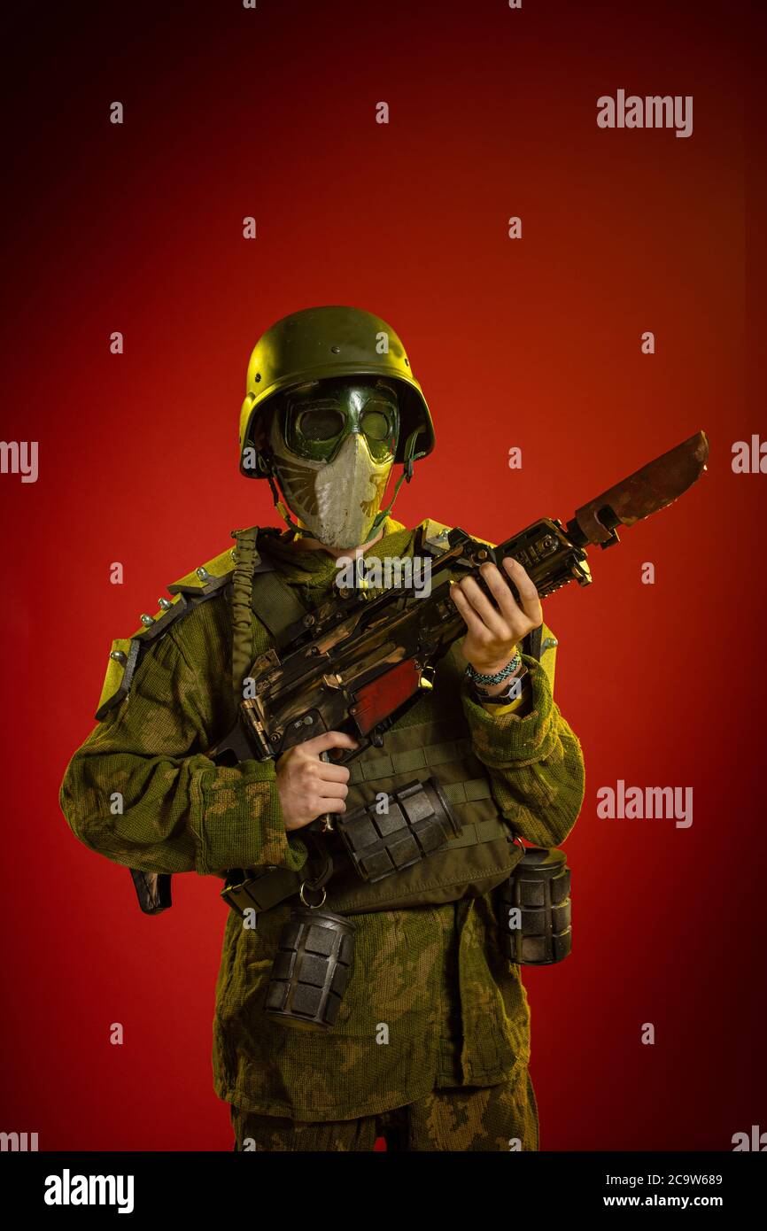 Actor man in a military helmet, mask and uniform posing on a red ...