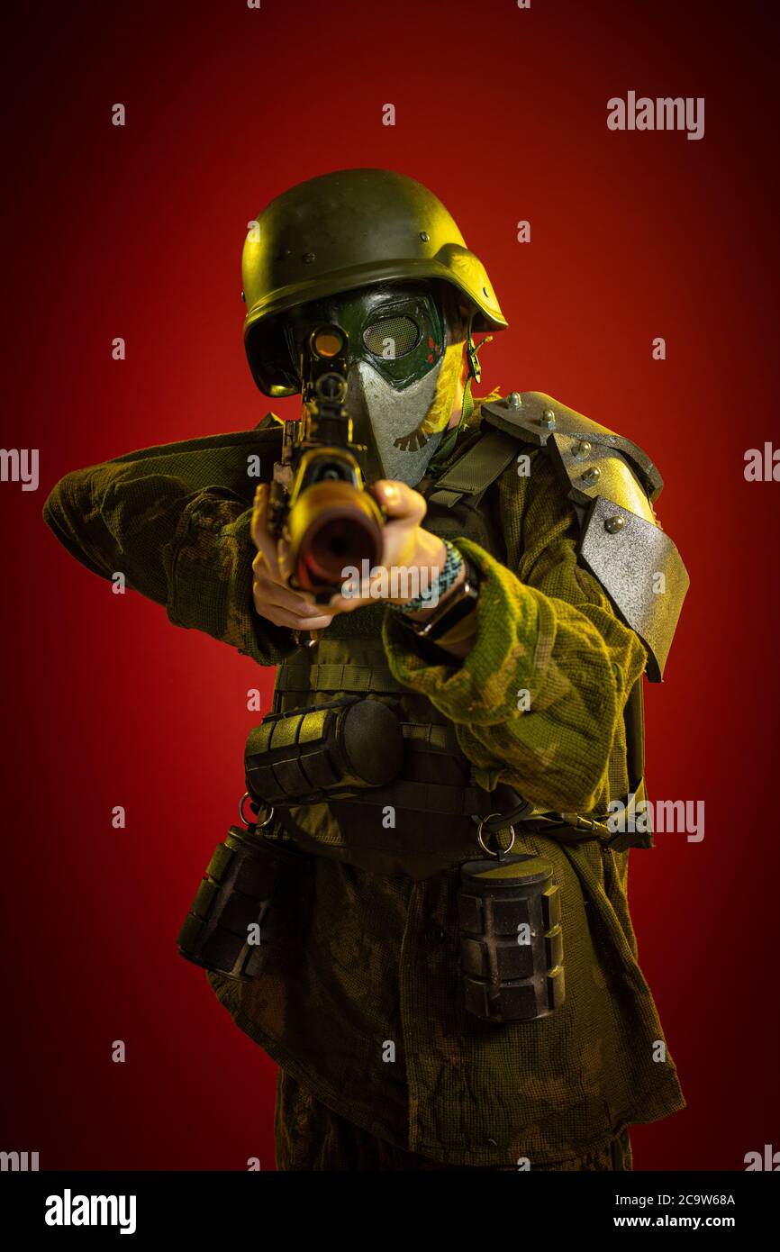 Actor man in a military helmet, mask and uniform posing on a red ...