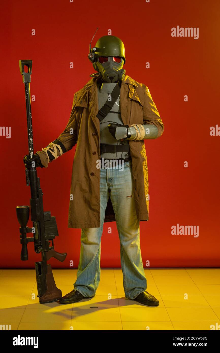 Actor man in a military helmet, mask and uniform with a gauss rifle in ...