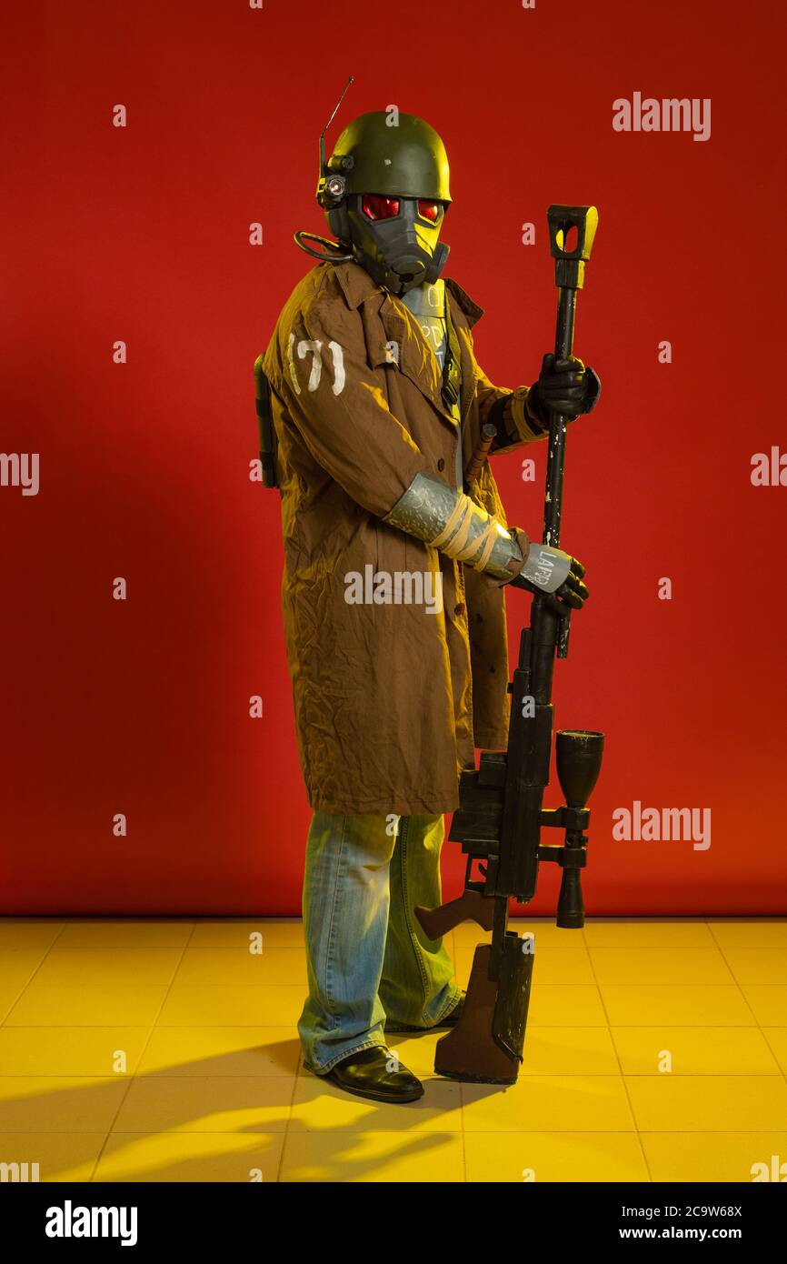 Actor man in a military helmet, mask and uniform with a gauss rifle in ...