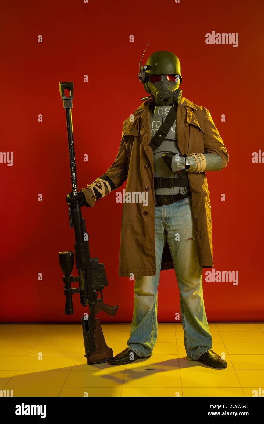 Actor man in a military helmet, mask and uniform posing on a red ...
