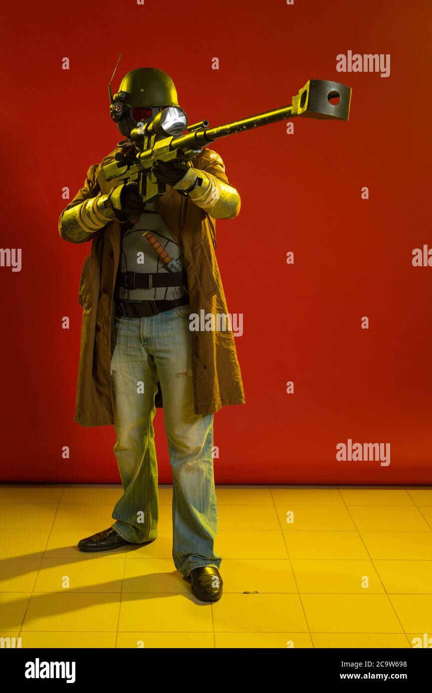 Actor man in a military helmet, mask and uniform with a gauss rifle in ...