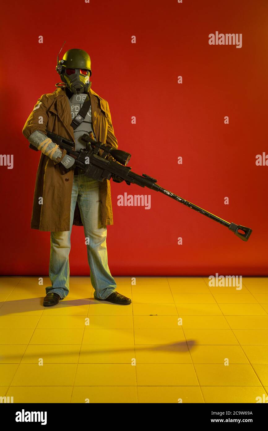 Actor man in a military helmet, mask and uniform posing on a red ...