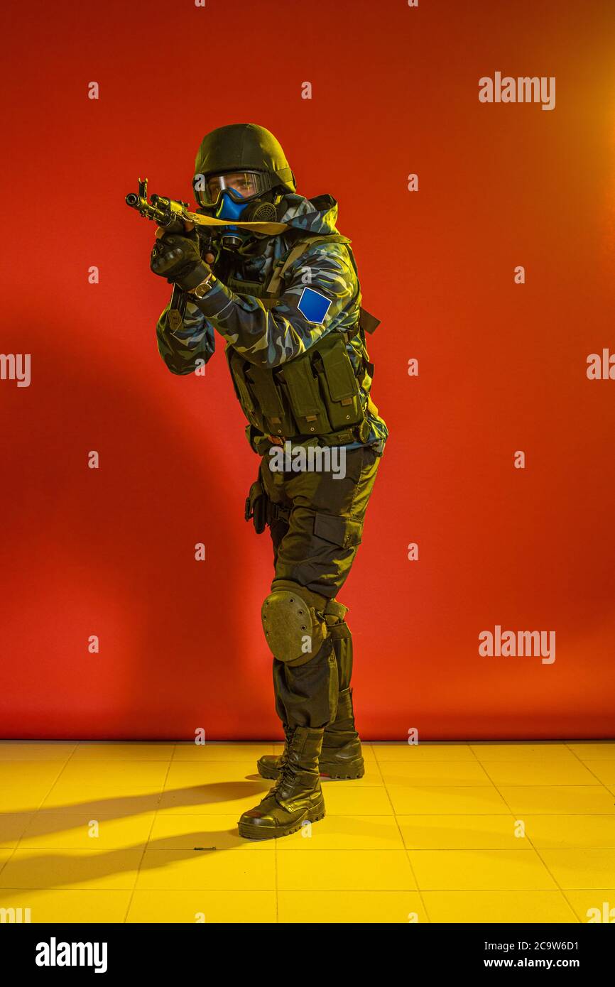 Actor man in a military helmet, mask and uniform posing on a red ...