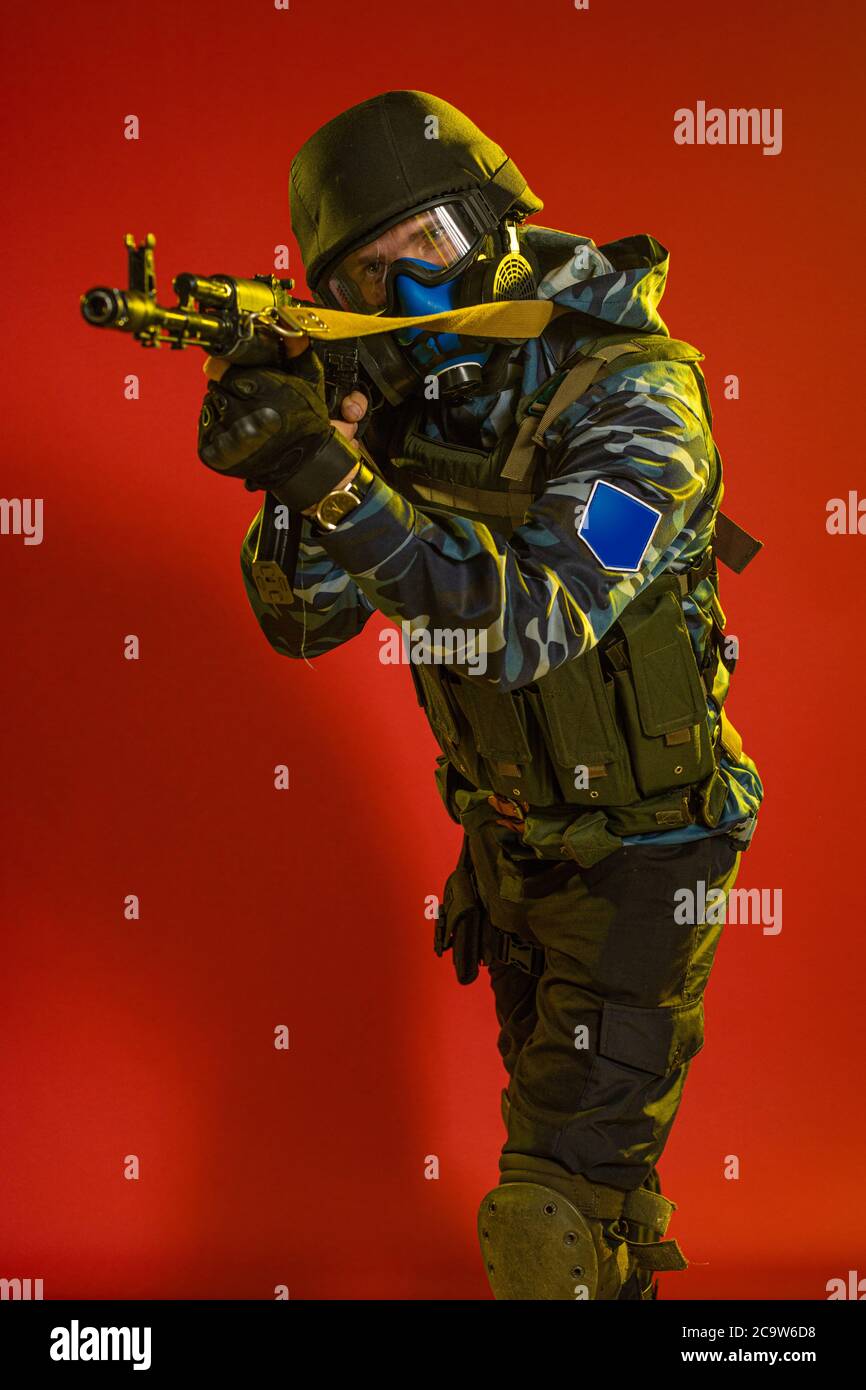 Actor man in a military helmet, mask and uniform posing on a red ...