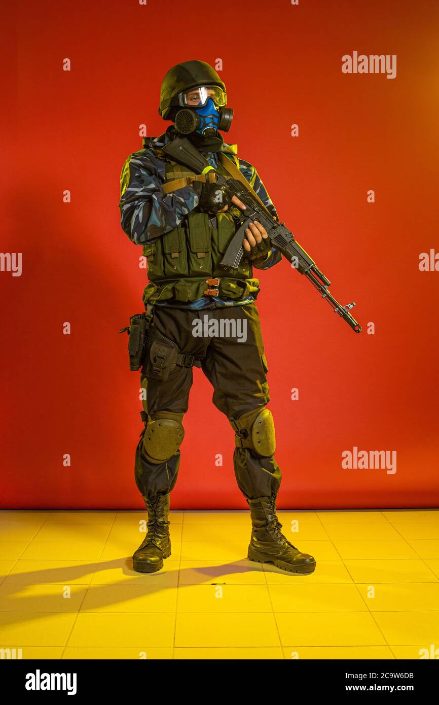 Actor man in a military helmet, mask and uniform posing on a red ...