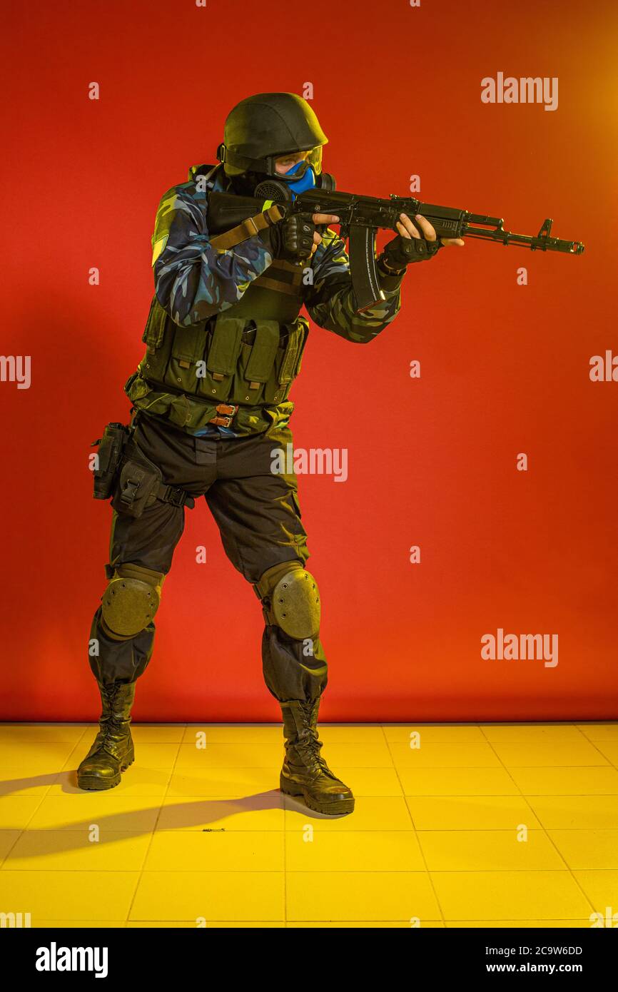 Actor man in a military helmet, mask and uniform posing on a red ...