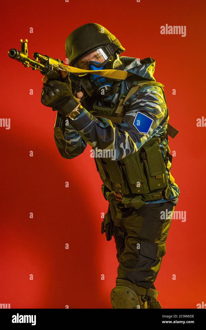 Actor man in a military helmet, mask and uniform posing on a red ...