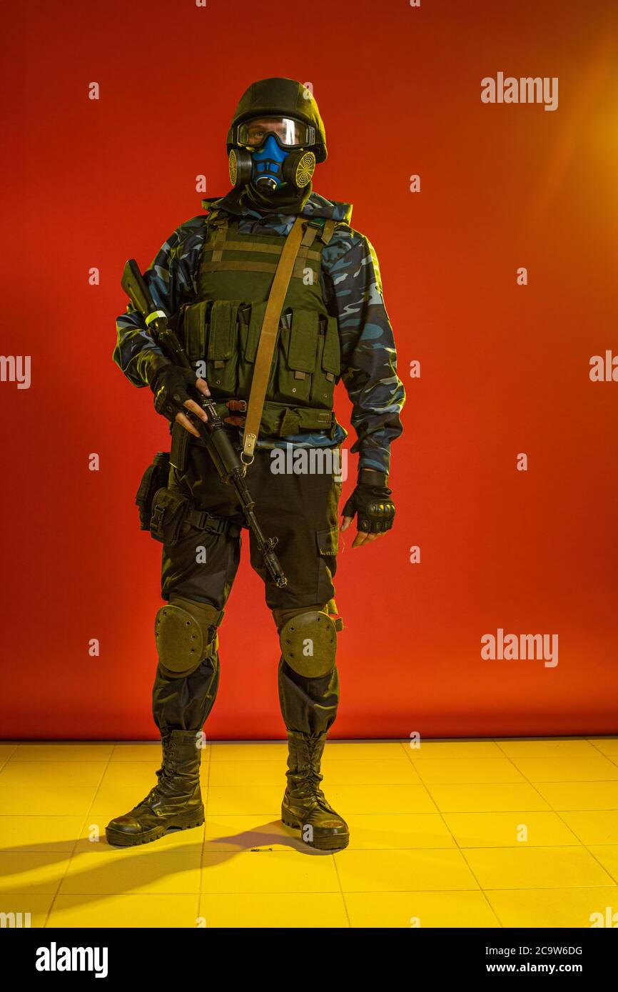 Actor man in a military helmet, mask and uniform posing on a red ...