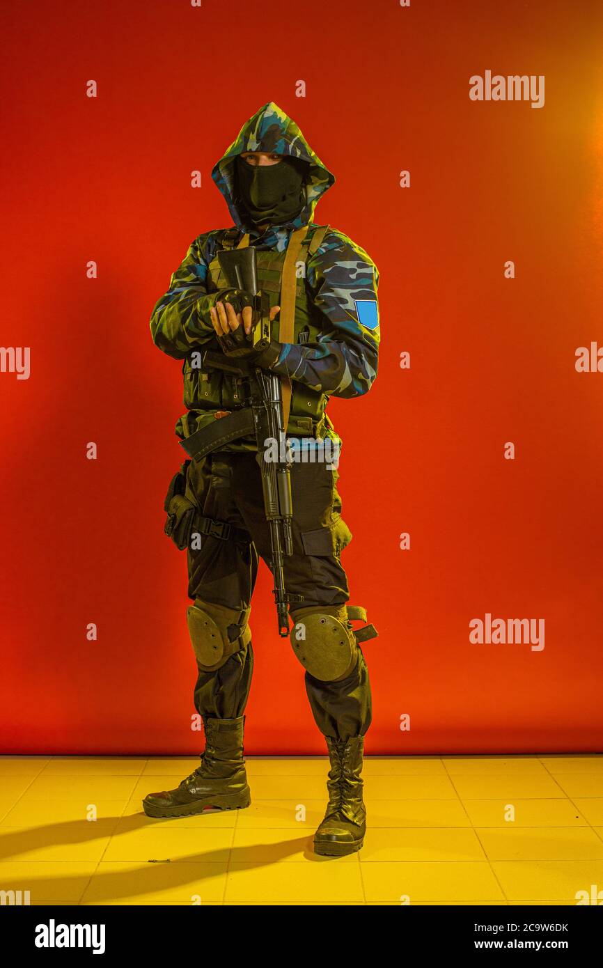 Actor man in a military helmet, mask and uniform posing on a red ...