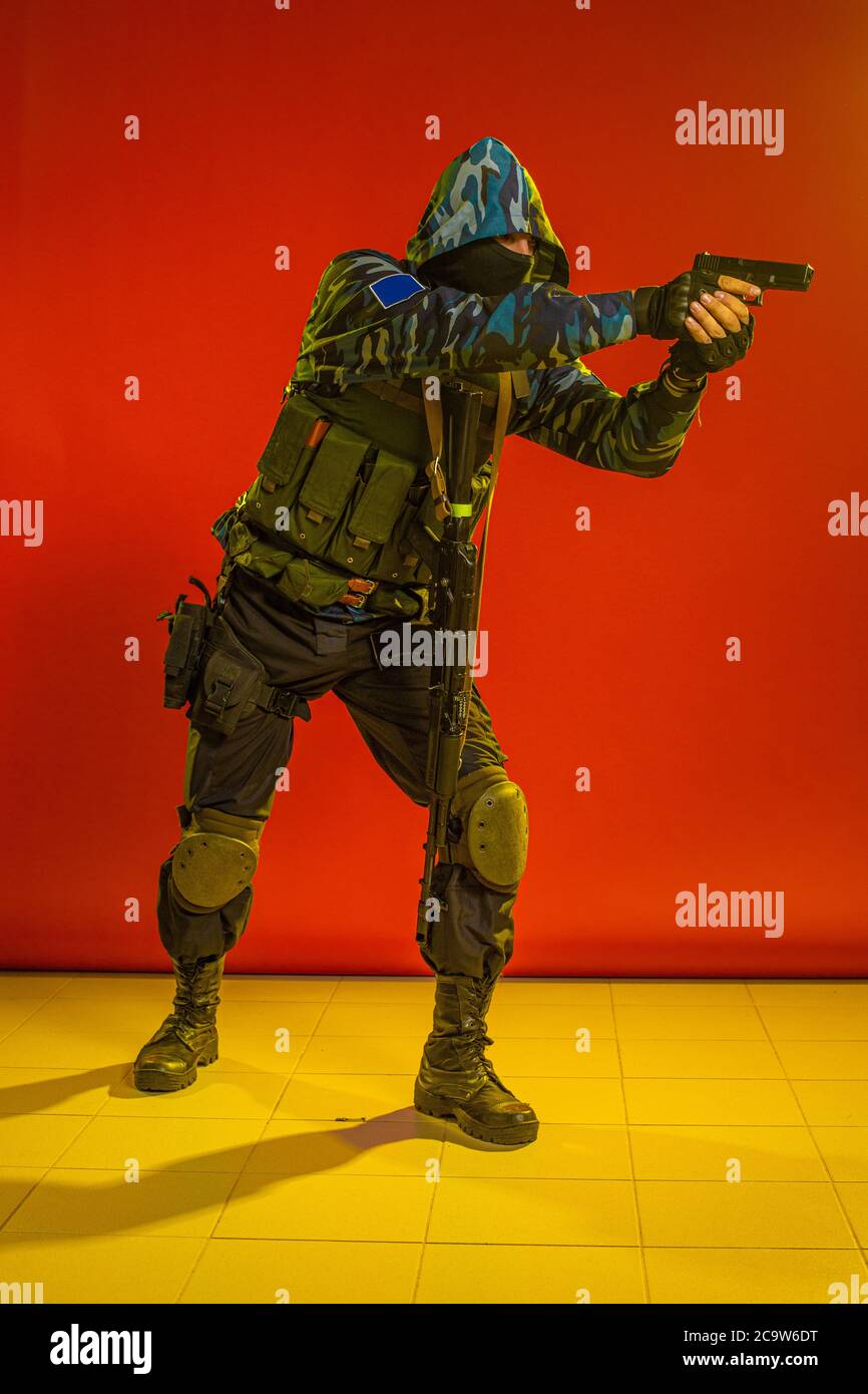 Actor man in a military helmet, mask and uniform posing on a red ...