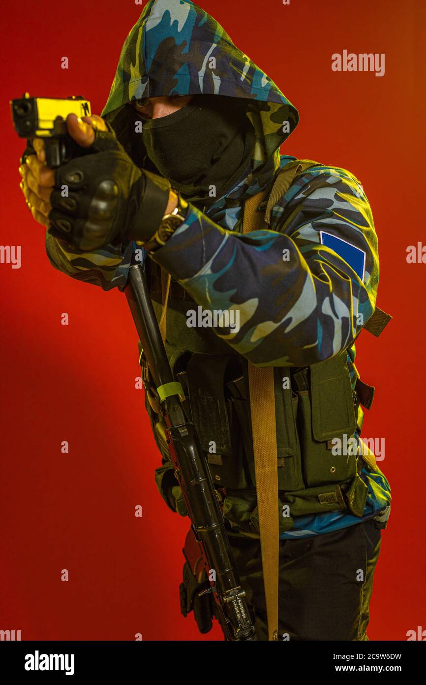 Actor man in a military helmet, mask and uniform posing on a red ...