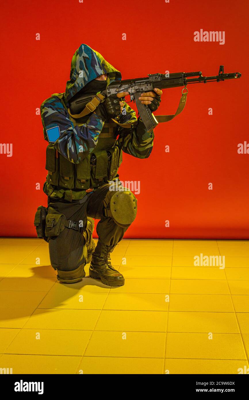 Actor man in a military helmet, mask and uniform posing on a red ...