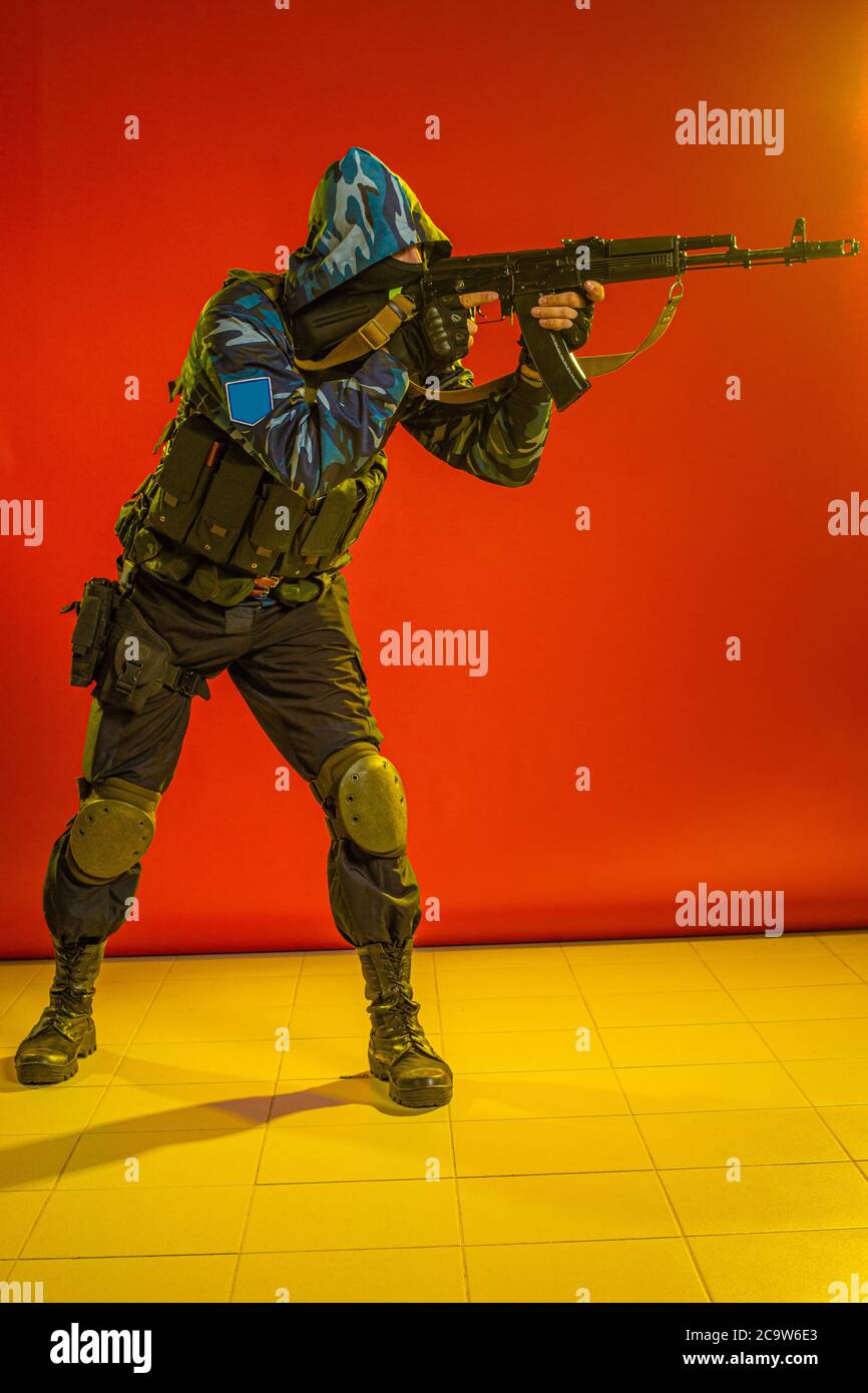 Actor man in a military helmet, mask and uniform posing on a red ...