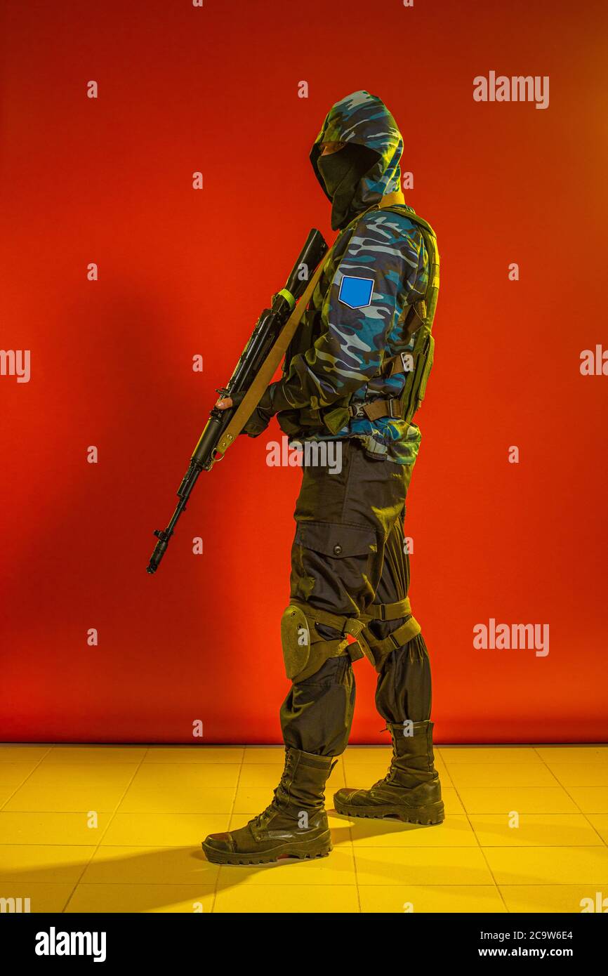 Actor man in a military helmet, mask and uniform posing on a red ...
