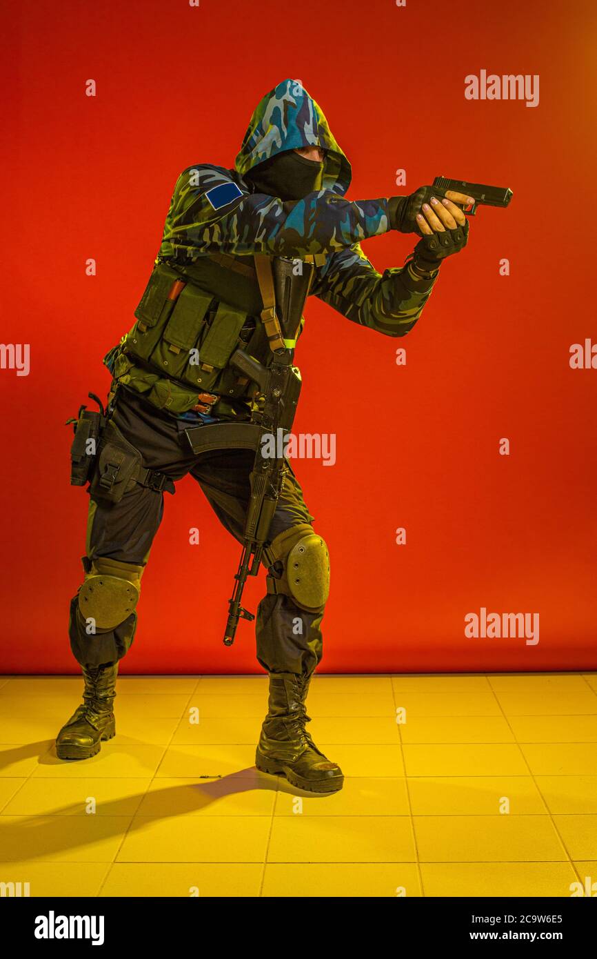 Actor man in a military helmet, mask and uniform posing on a red ...