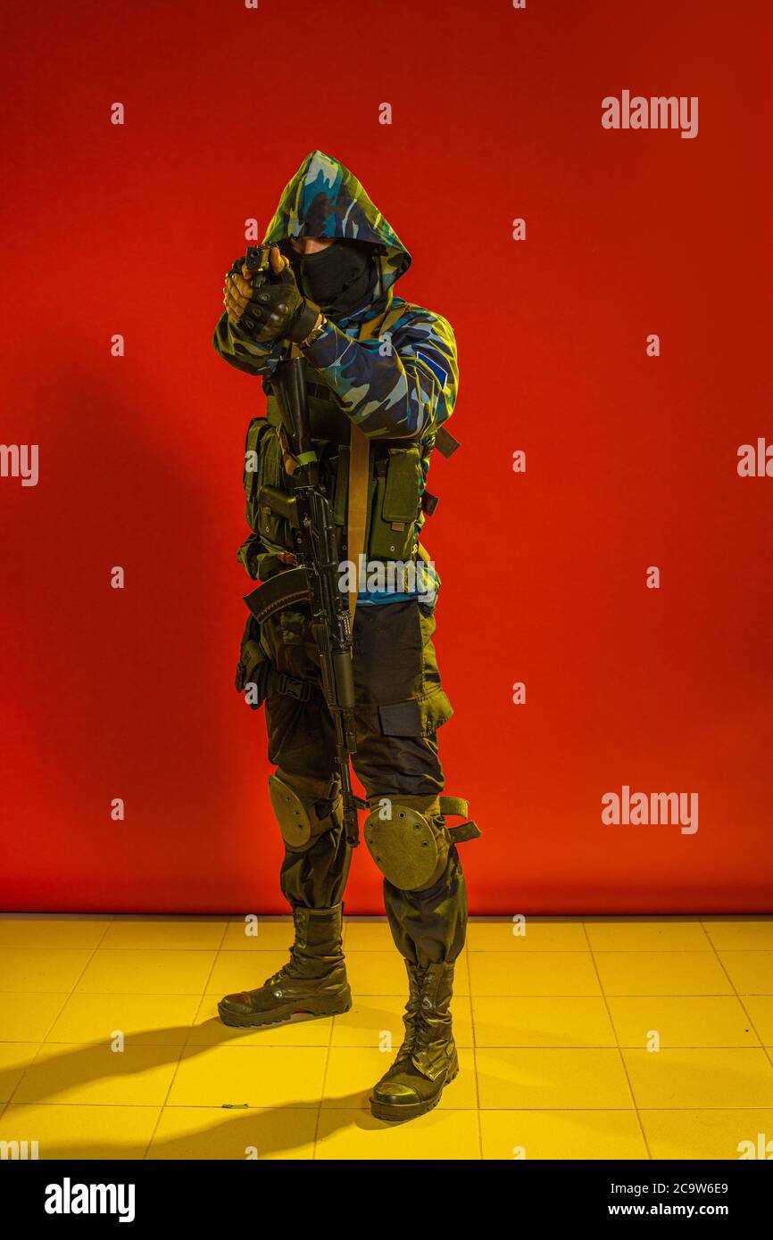 Actor man in a military helmet, mask and uniform posing on a red ...