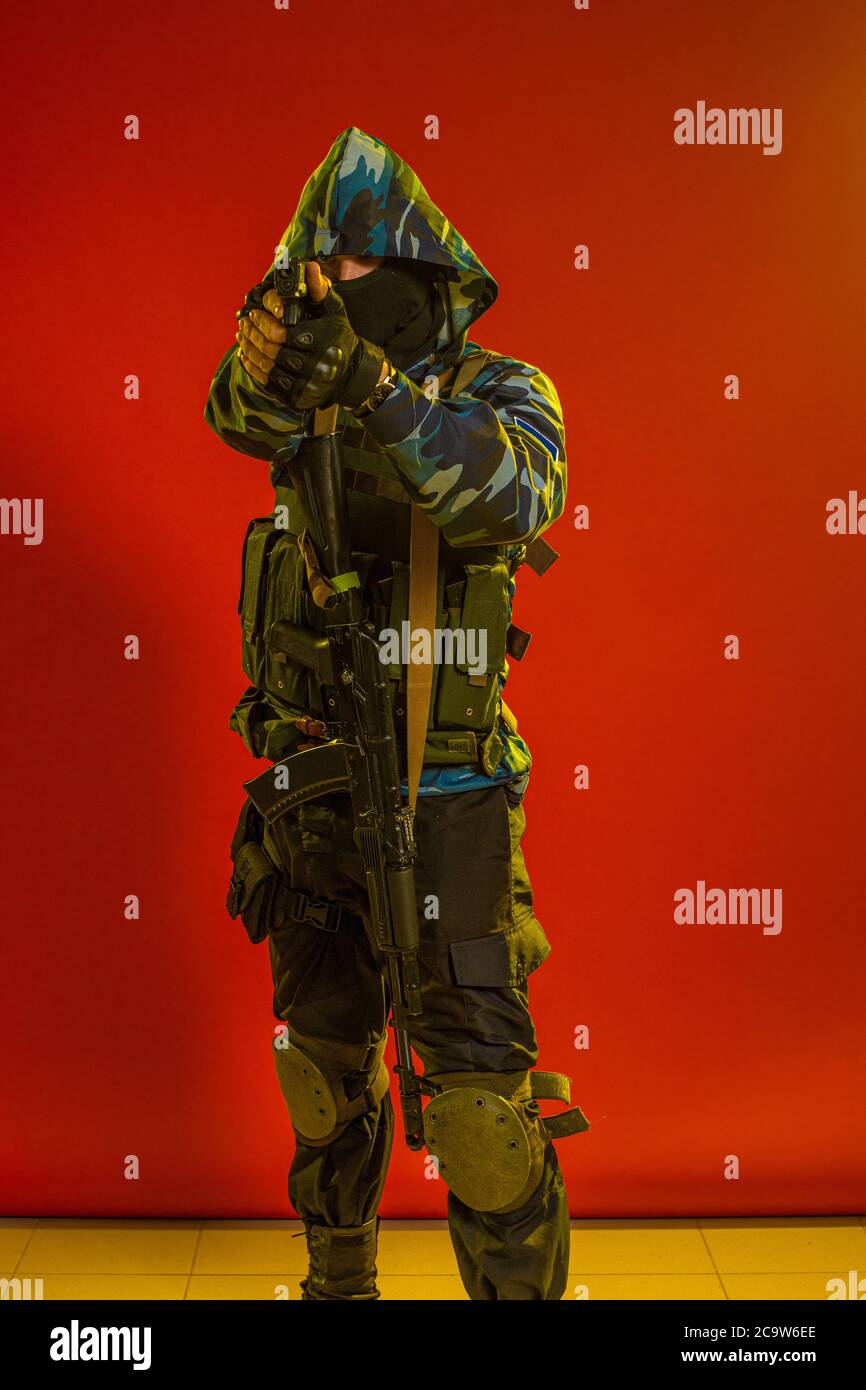 Actor man in a military helmet, mask and uniform posing on a red ...