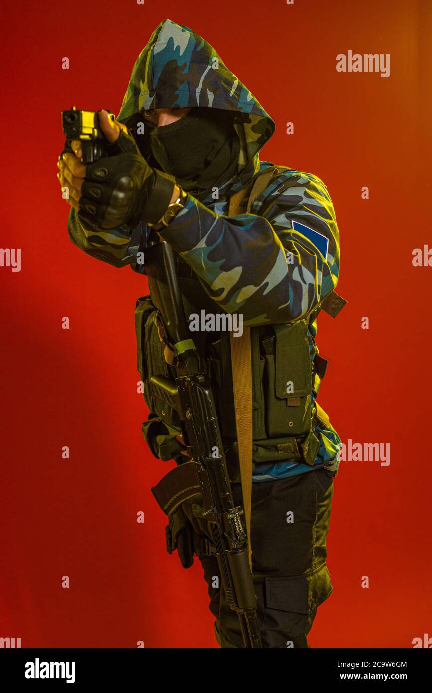 Actor man in a military helmet, mask and uniform posing on a red ...