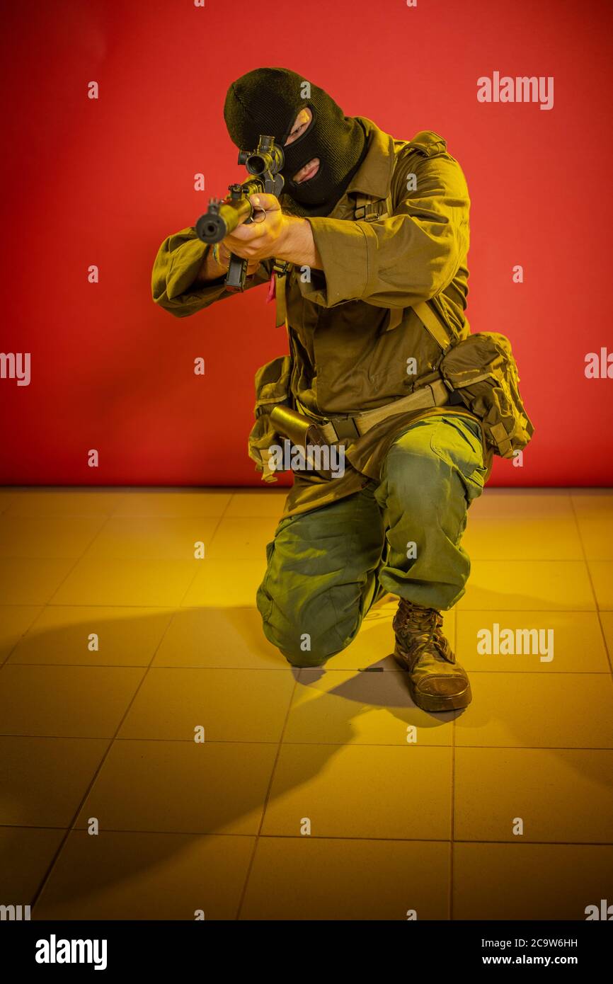 Actor man in a military helmet, mask and uniform posing on a red ...