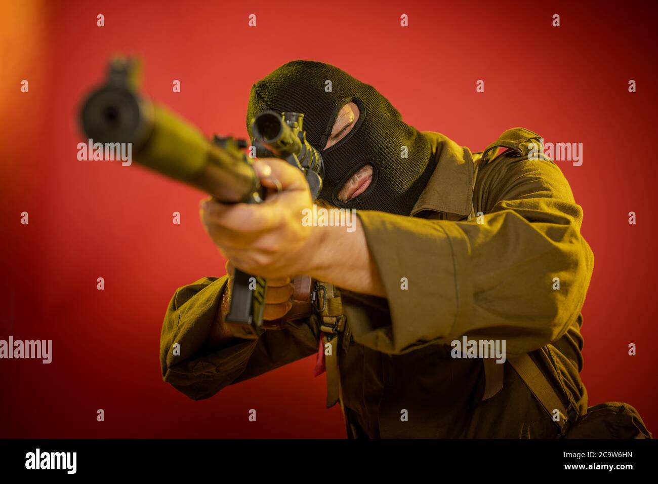 Actor man in a military helmet, mask and uniform posing on a red ...