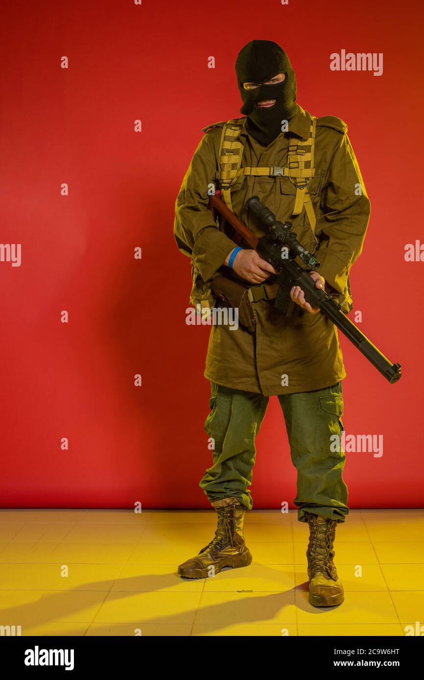 Actor man in a military helmet, mask and uniform posing on a red ...