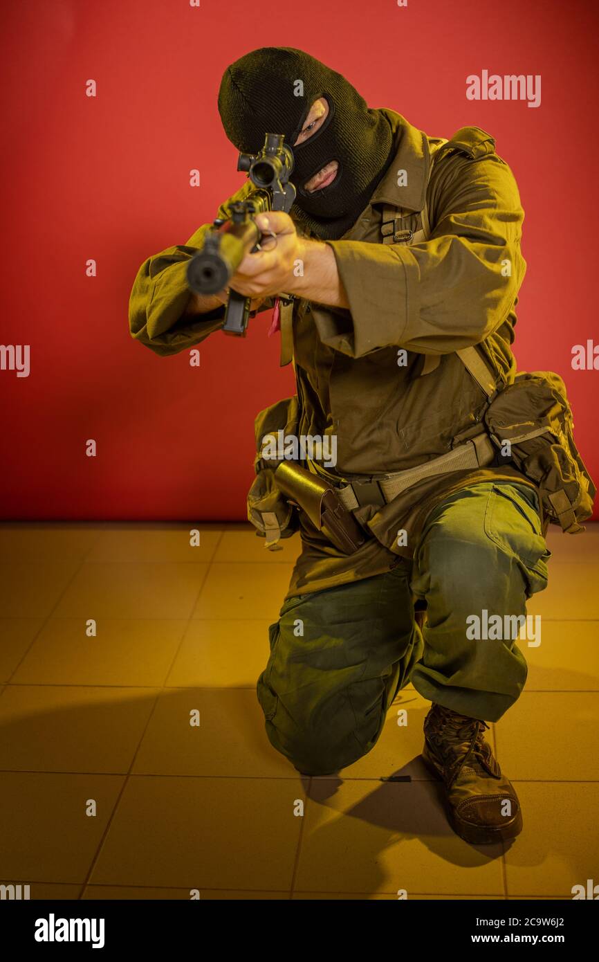 Actor man in a military helmet, mask and uniform posing on a red ...