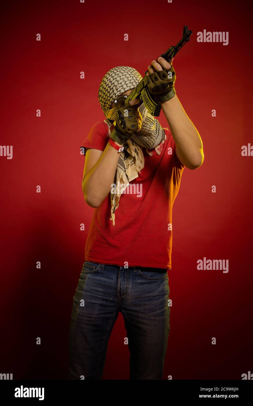 Actor man in a military helmet, mask and uniform posing on a red ...