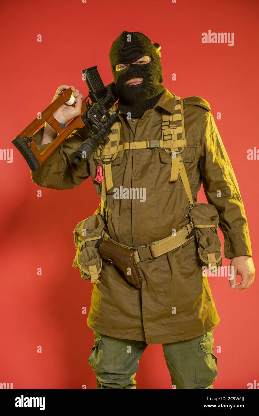 Actor man in a military helmet, mask and uniform posing on a red ...