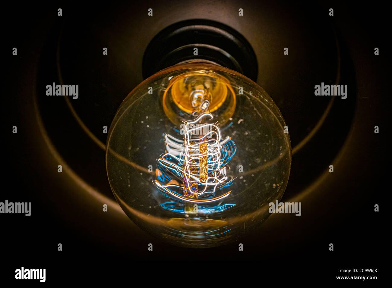 An Edison style light bulb in an industrial light Stock Photo - Alamy