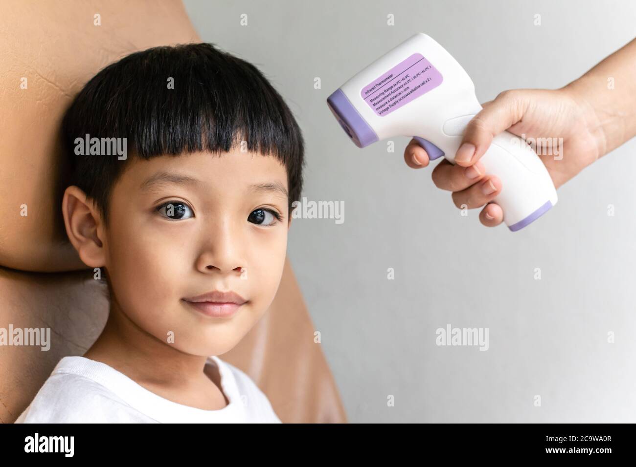 Checking measure fever levels asian little child using digital infrared ...