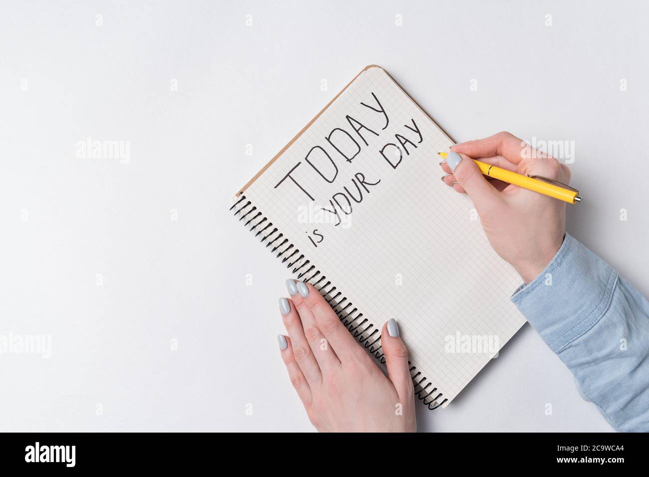 Motivational inscription TODAY IS YOUR DAY. Top view of woman writing ...