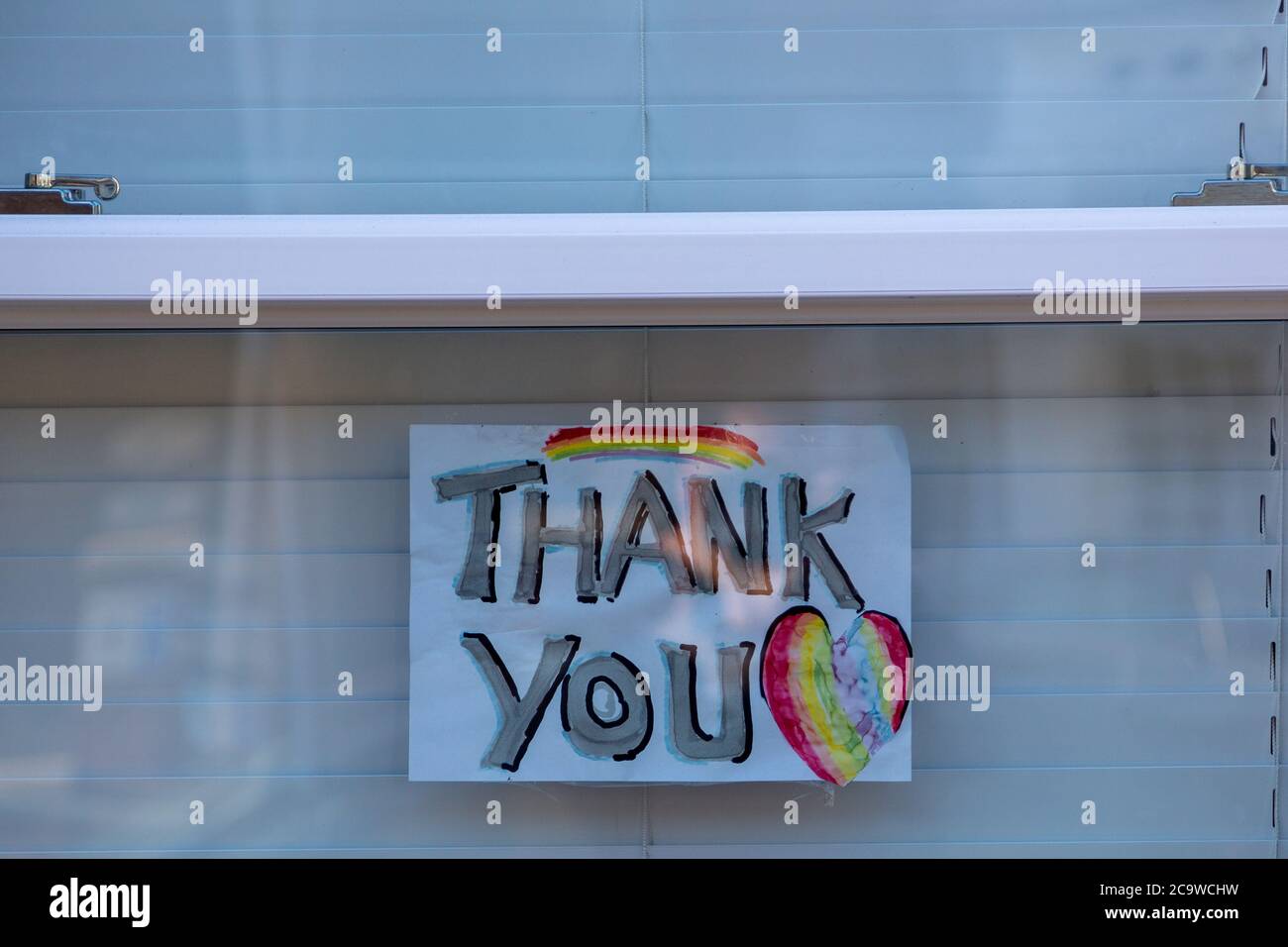 A thank you sign in a window drawn by a child during the Covid-19 or ...