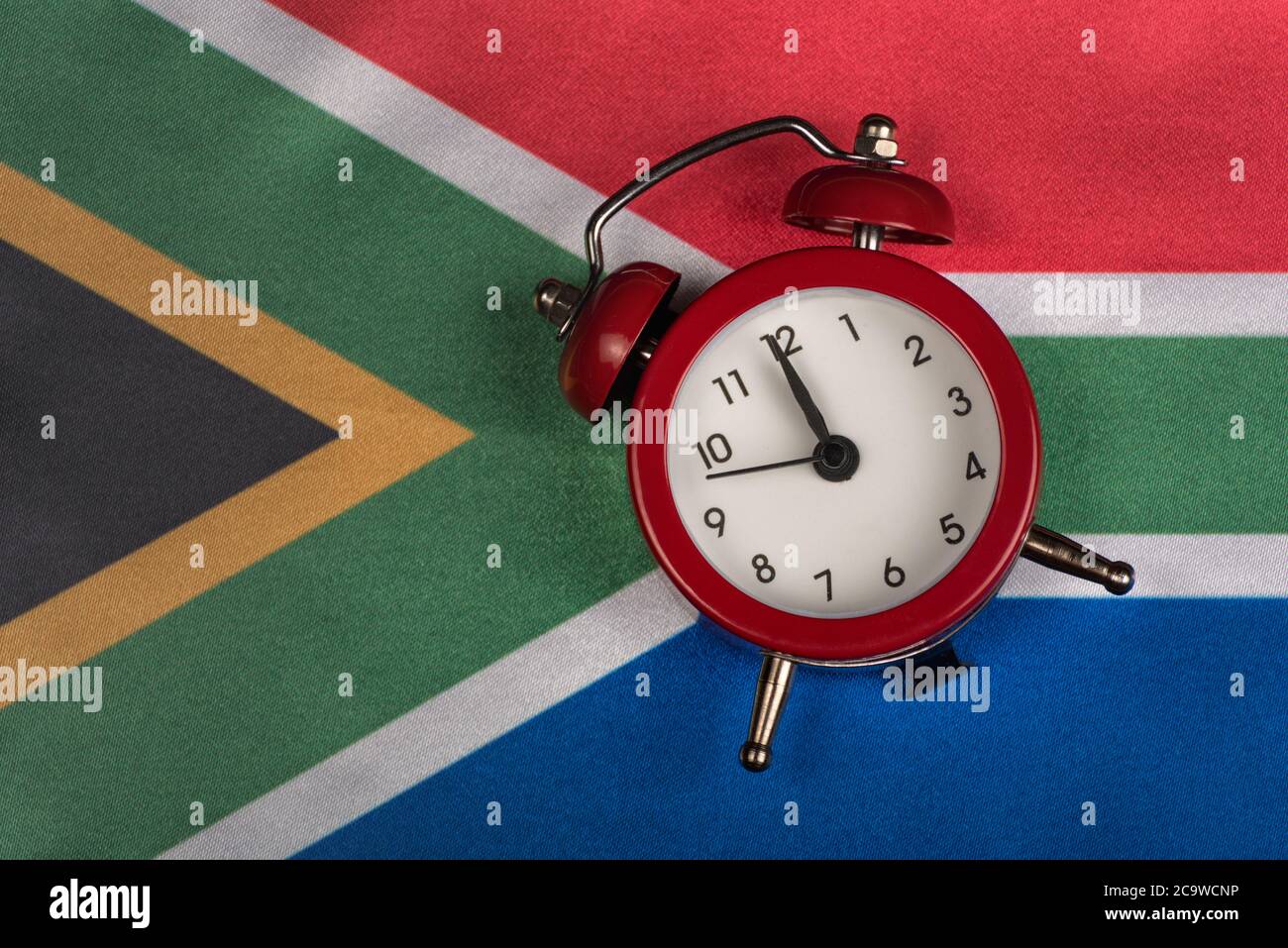 National flag of Republic of South Africa and vintage alarm clock close ...