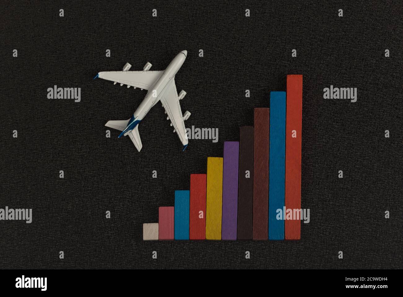 Colorful chart and model airplane on black background. Statistics of ...
