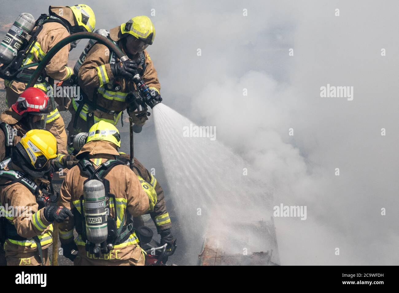 Firefighter spray water on roof with hose. Editorial use only Stock ...