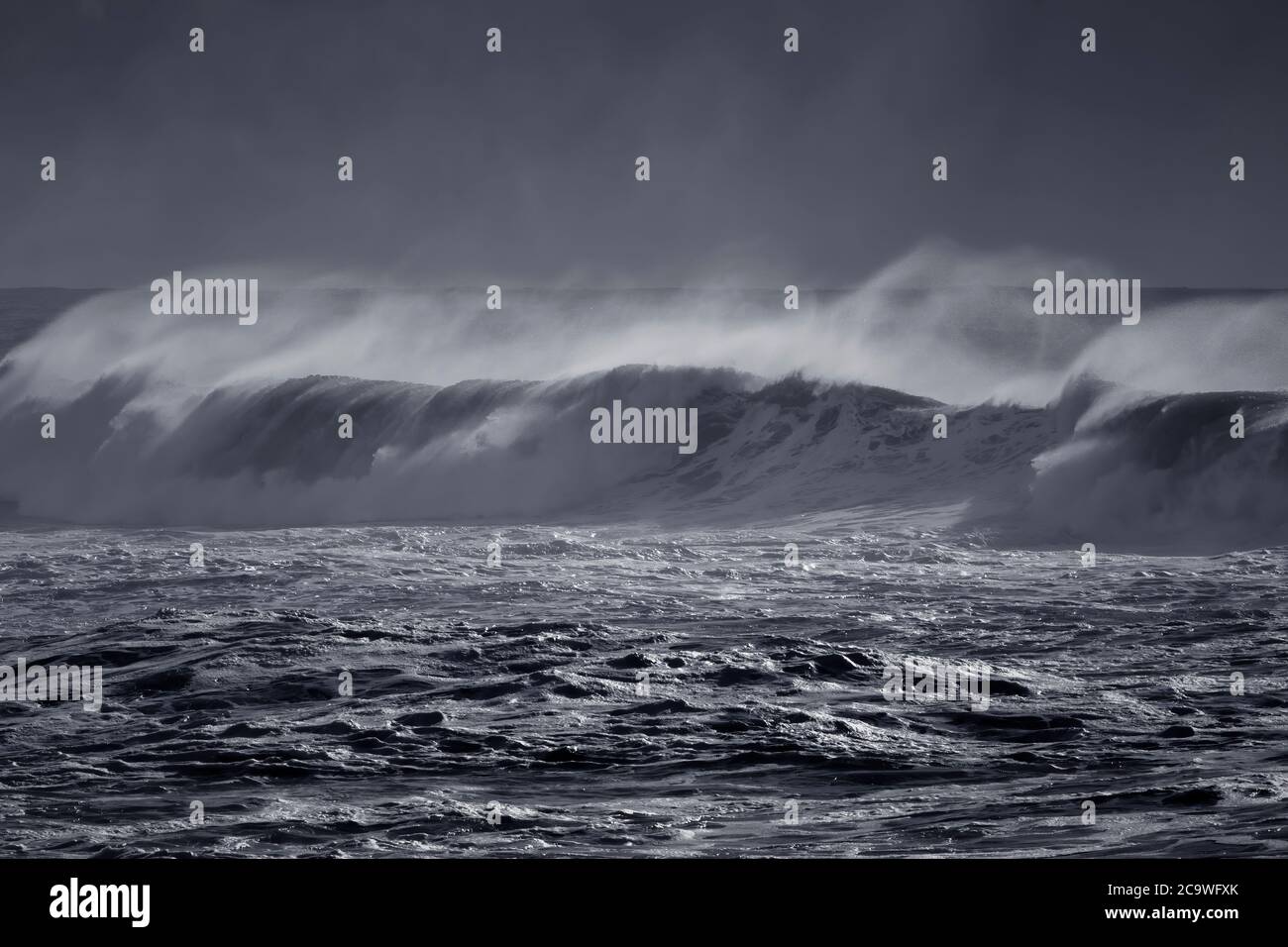 Windy long wave with spray Stock Photo - Alamy
