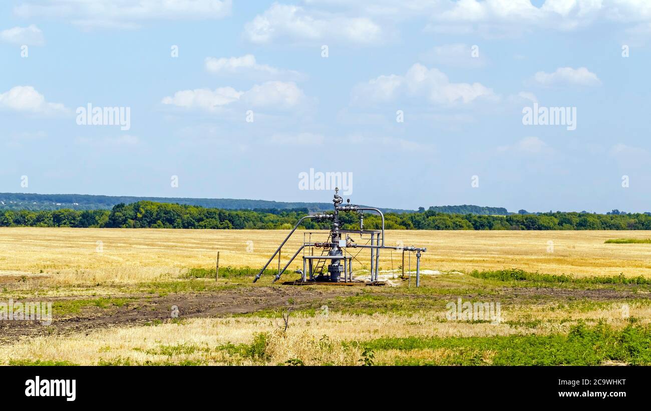 Landscape with the oil well Christmas tree in the field Stock Photo - Alamy