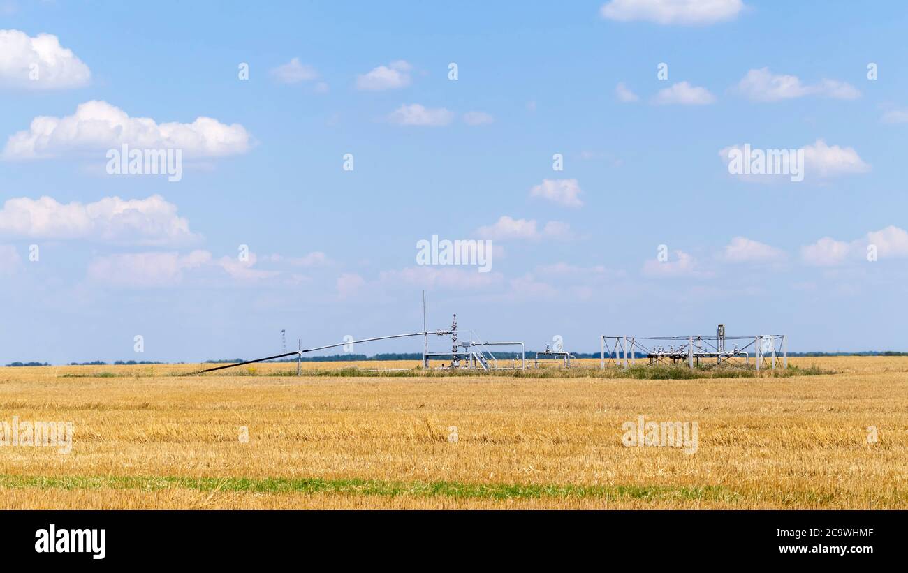 Landscape with the oil well Christmas tree and pipelines in the field ...