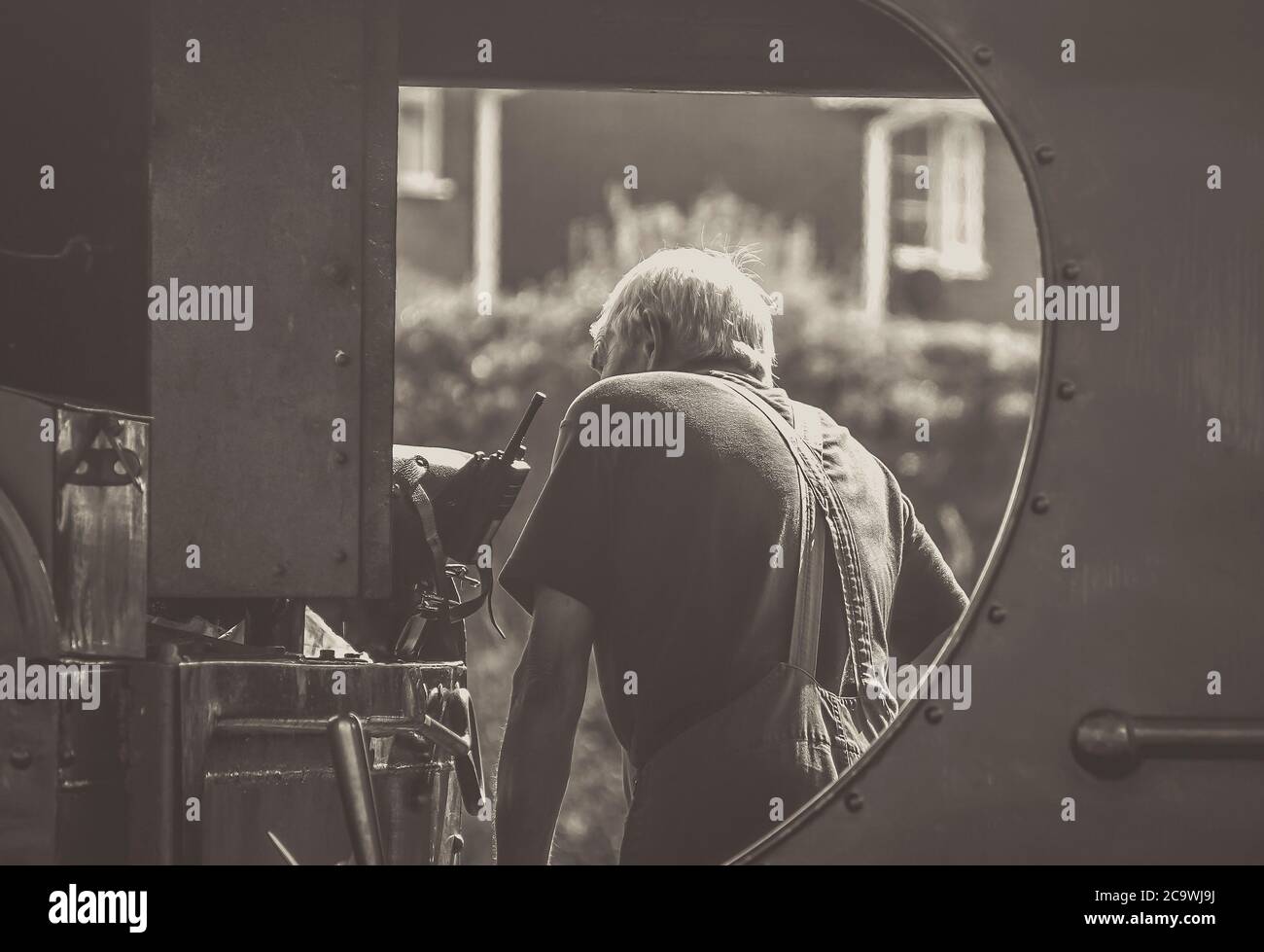 Rear view close up of British steam train driver in cab of vintage UK ...