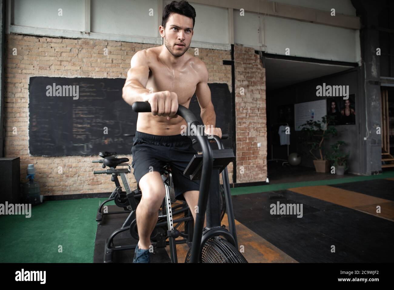 Man using exercise bike at the gym. Fitness male using air bike for ...