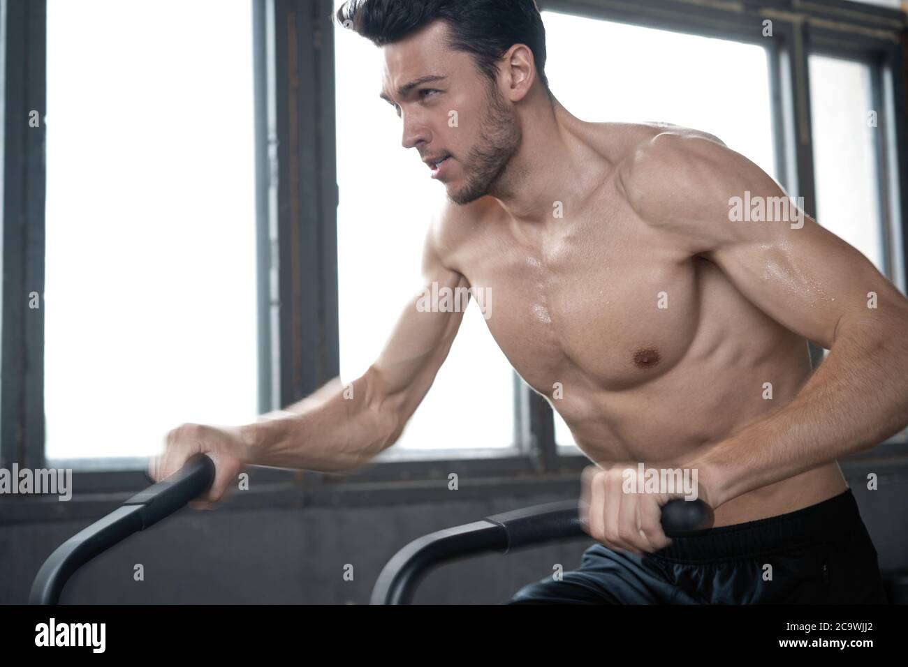 Man using exercise bike at the gym. Fitness male using air bike for ...