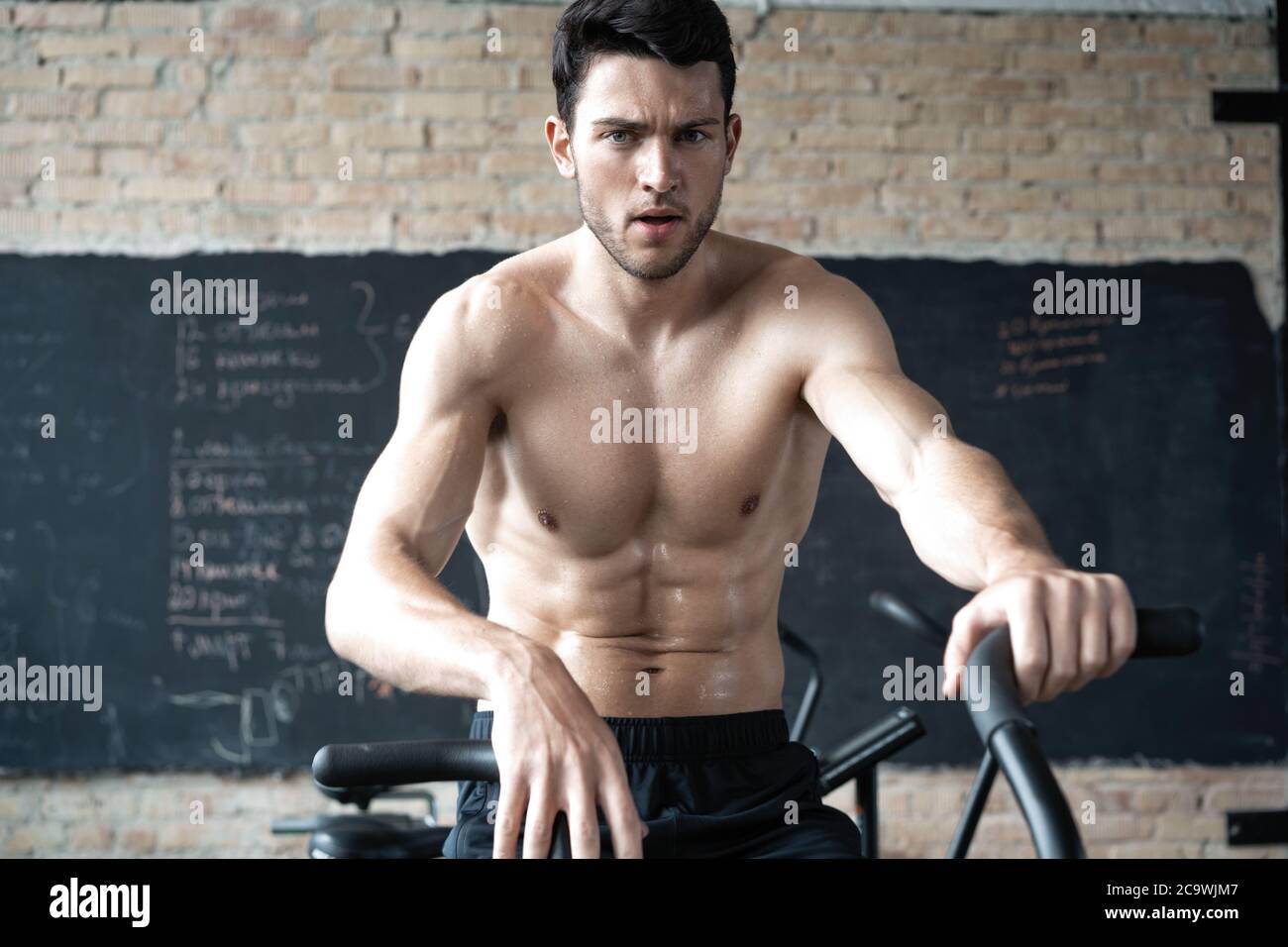 Man using exercise bike at the gym. Fitness male using air bike for ...