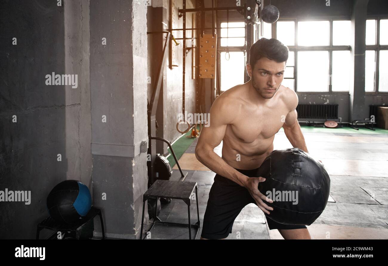 Young strong fit muscular man doing throwing medicine ball up on the ...