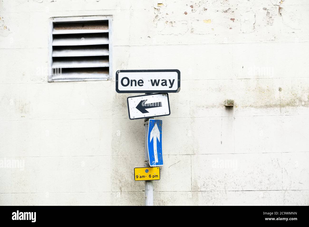 One way directional arrow sign against white wall background Stock ...