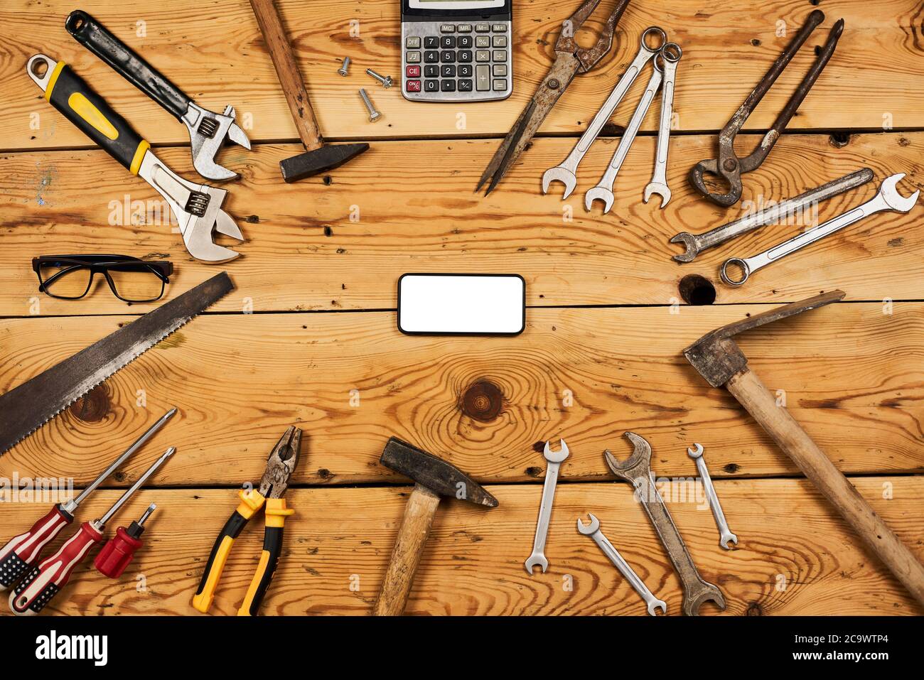Different handy tools placed around the mobile phone with blank screen ...