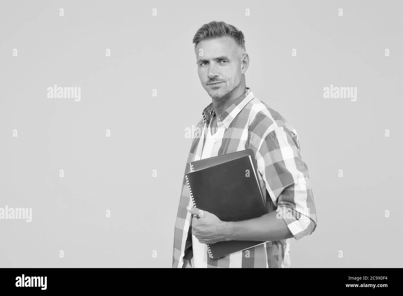 adult man student holding notebooks. man with folder yellow background ...