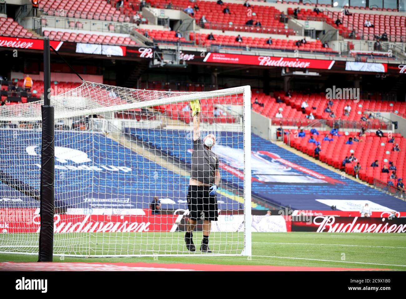 Wembley, UK. 01st Aug, 2020. A member of the pitch staff cleans the ...